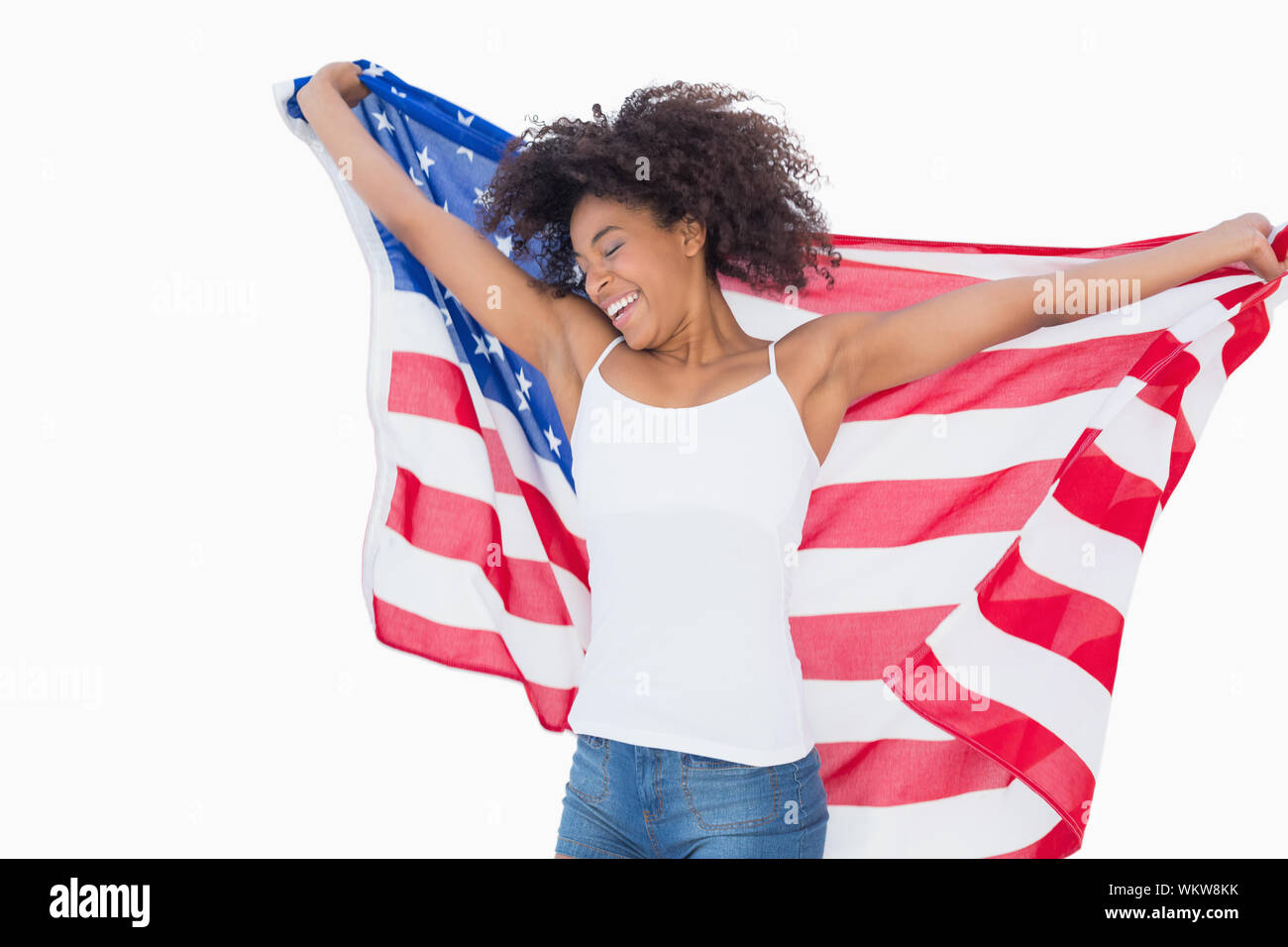 Pretty girl wrapped in american flag cheering on white background Stock ...