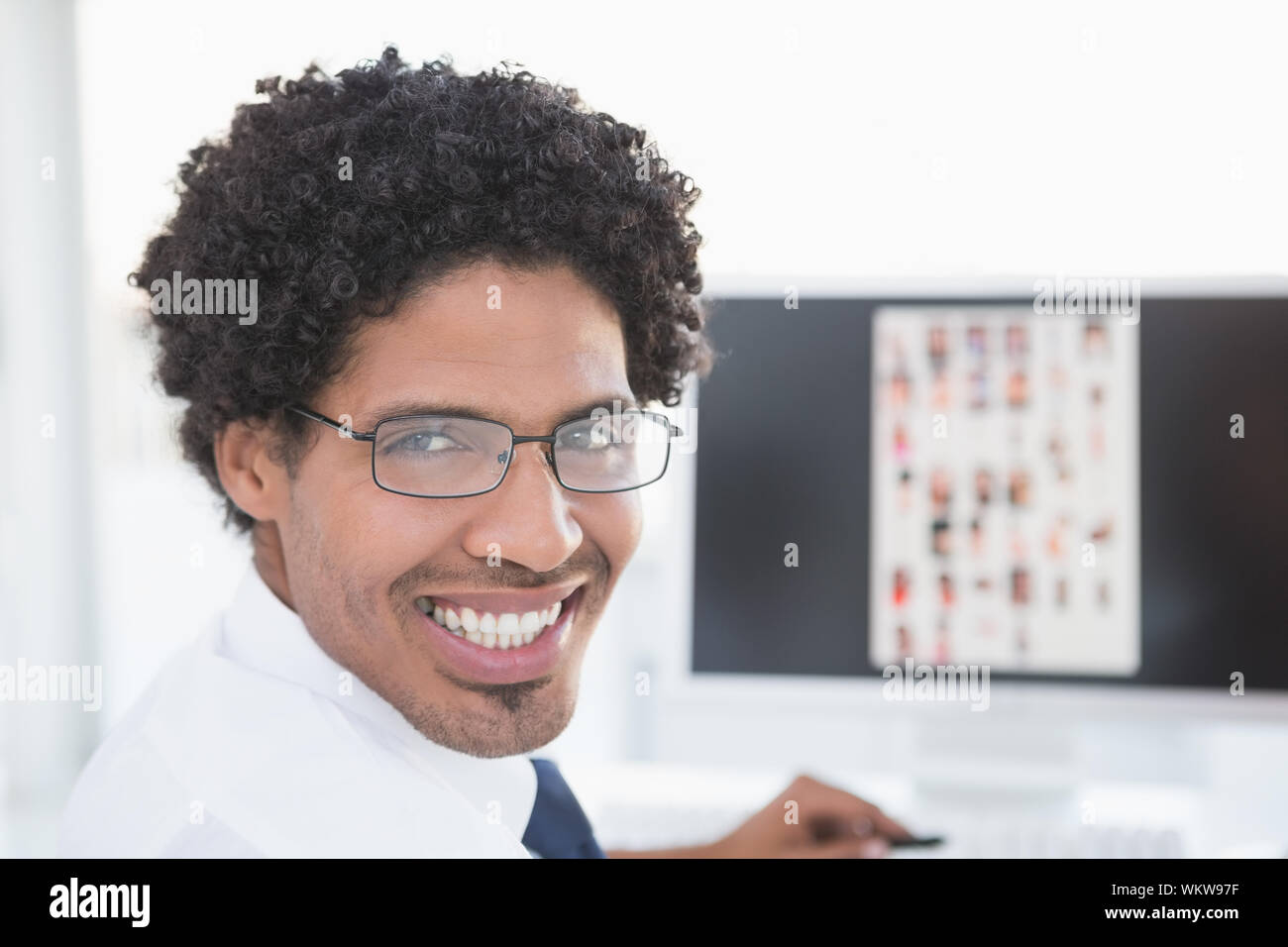 Young editor smiling at camera at his desk in creative office Stock ...