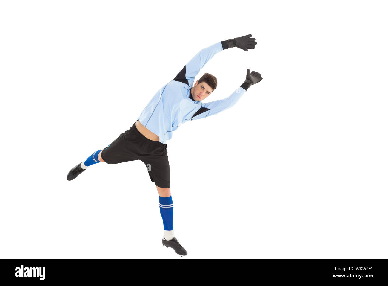 Goalkeeper in blue jumping up on white background Stock Photo - Alamy