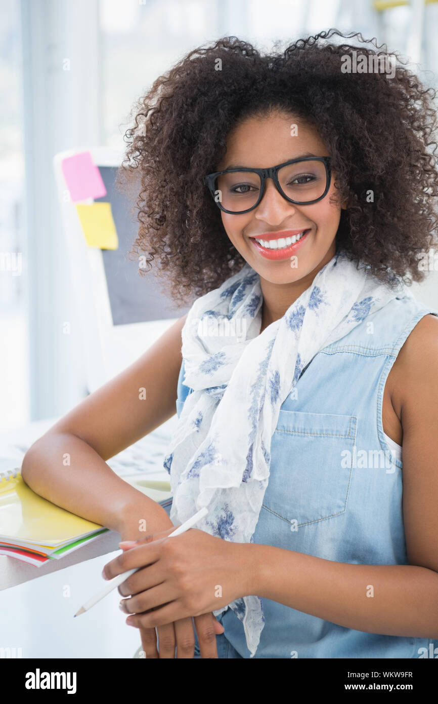 Pretty designer smiling at camera in her office Stock Photo - Alamy