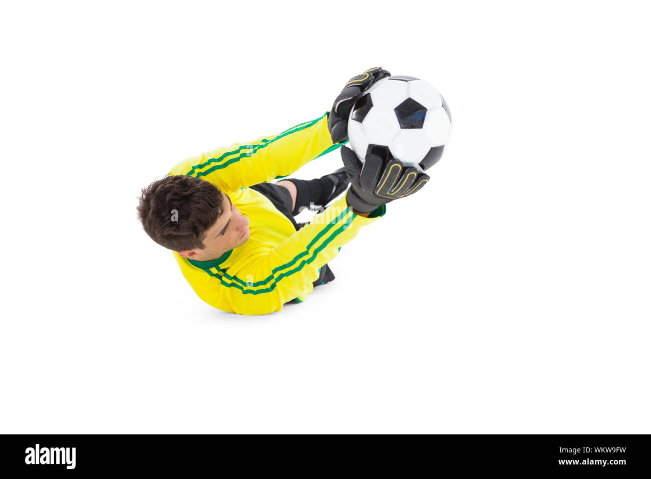 Goalkeeper in yellow holding ball on white background Stock Photo - Alamy