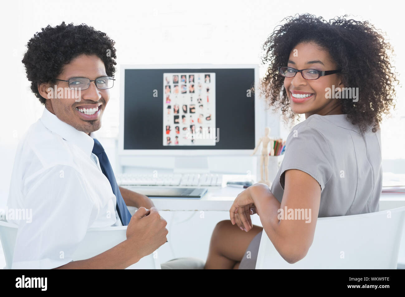 Young editorial team working together smiling at camera in creative ...