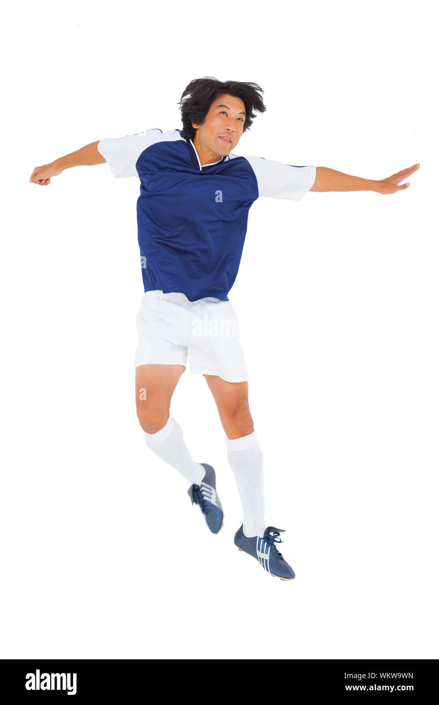 Football player in blue jumping on white background Stock Photo - Alamy