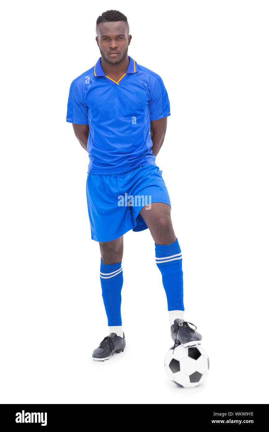 Football player in blue standing with ball on white background Stock ...
