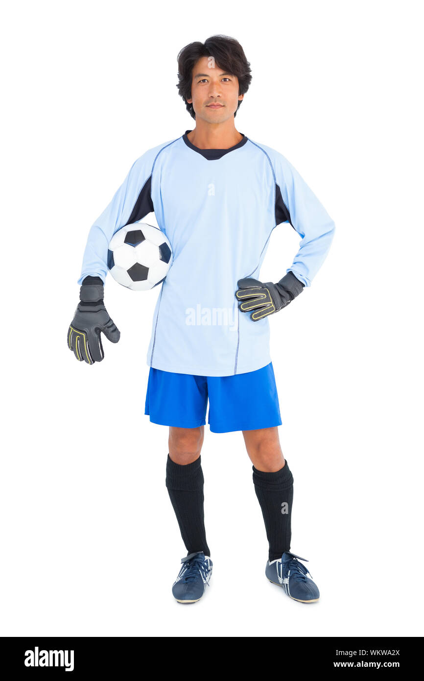 Goalkeeper in blue holding ball on white background Stock Photo - Alamy