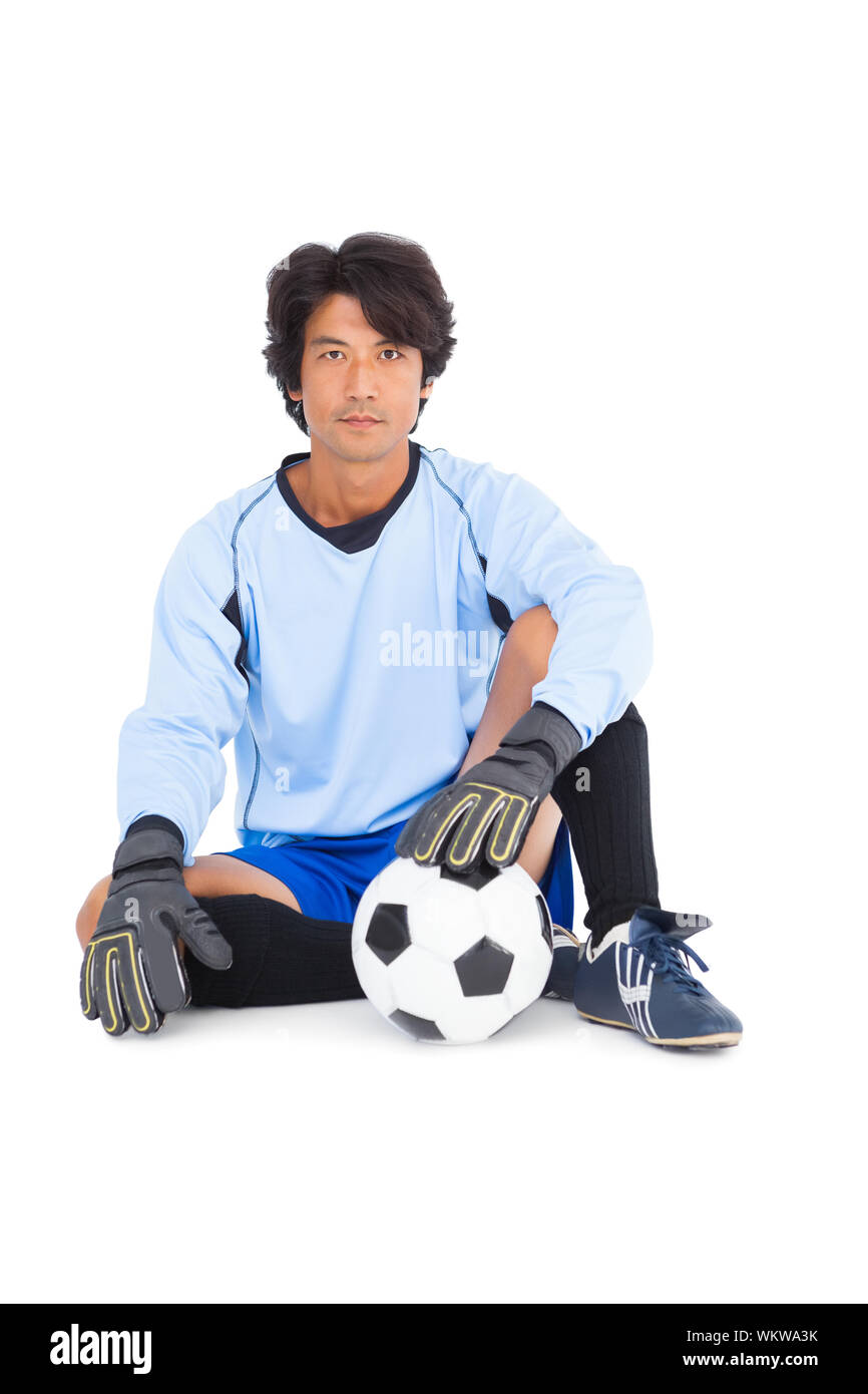 Goalkeeper in blue holding ball on white background Stock Photo - Alamy