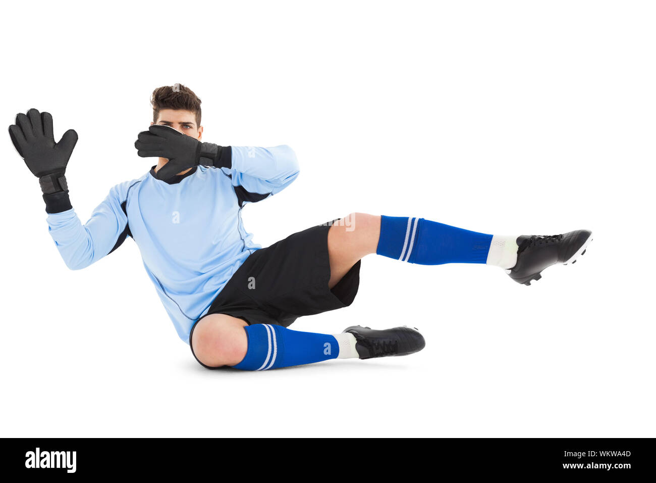 Goalkeeper in blue making a save on white background Stock Photo - Alamy