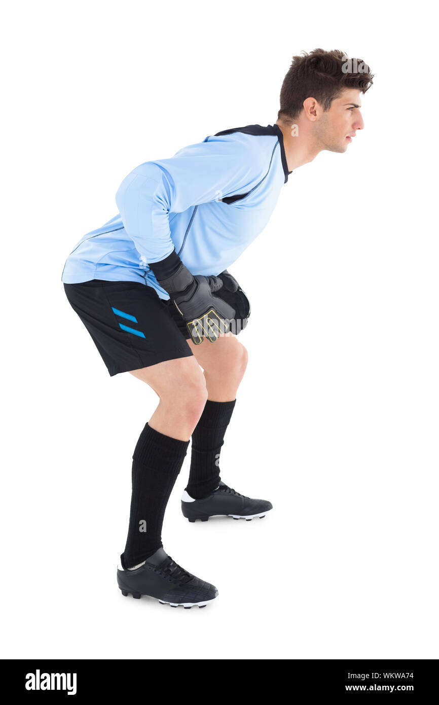 Goalkeeper in blue ready to save on white background Stock Photo - Alamy