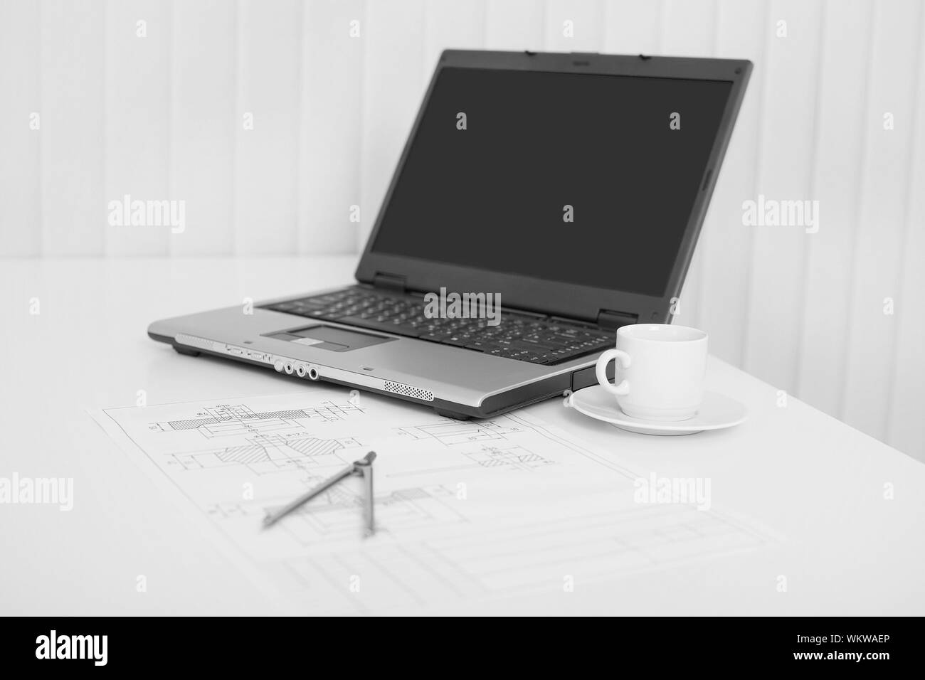 Desktop of the engineer with the laptop and the drawing on a paper ...