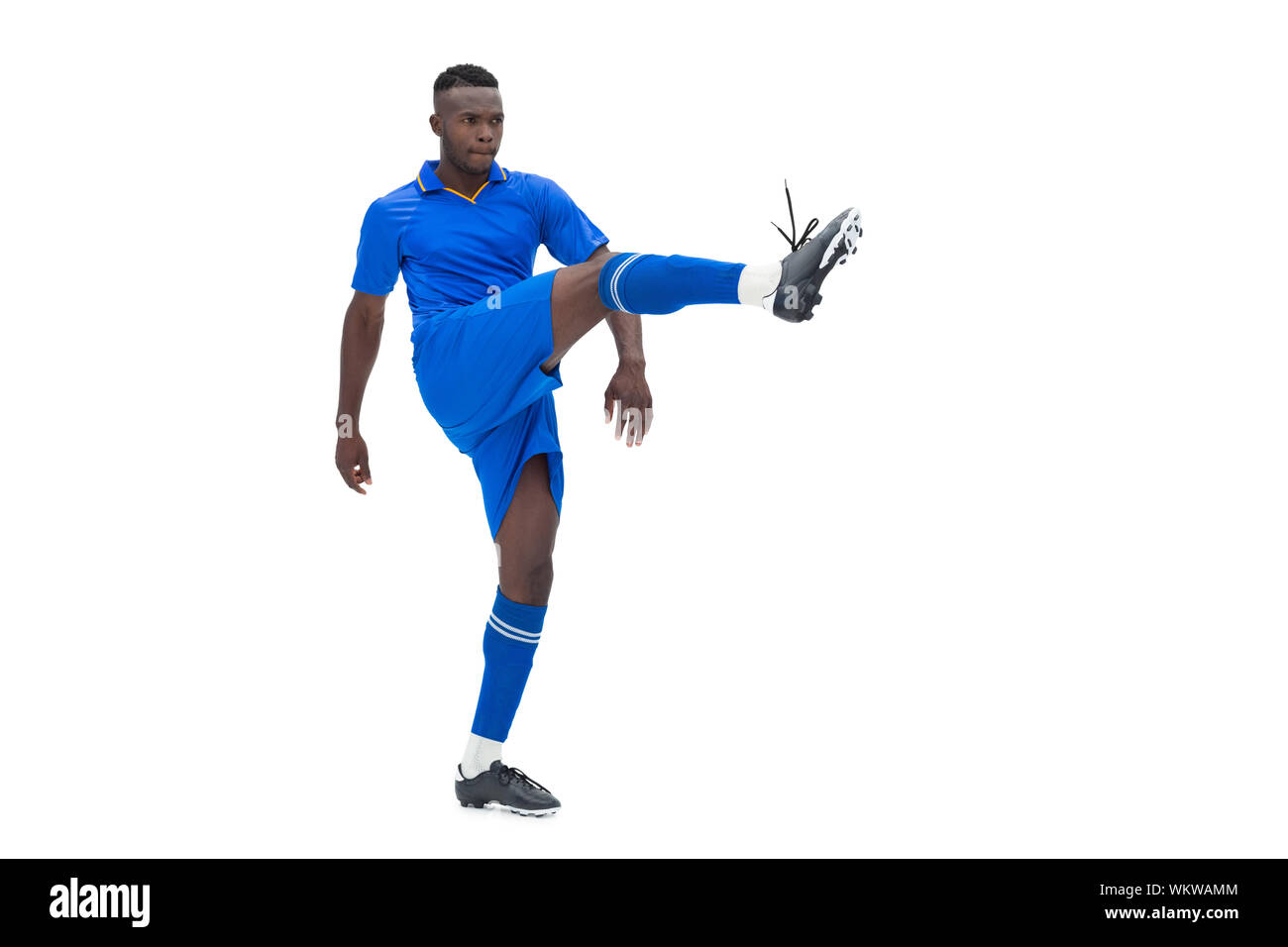 Football player in blue kicking on white background Stock Photo - Alamy