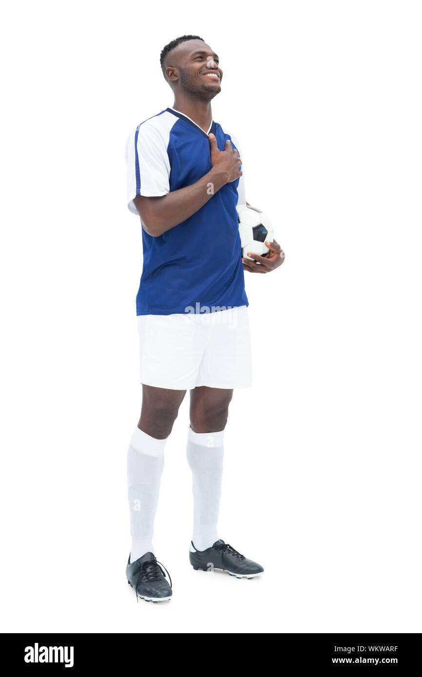 Football player in blue standing with the ball listening to anthem on ...