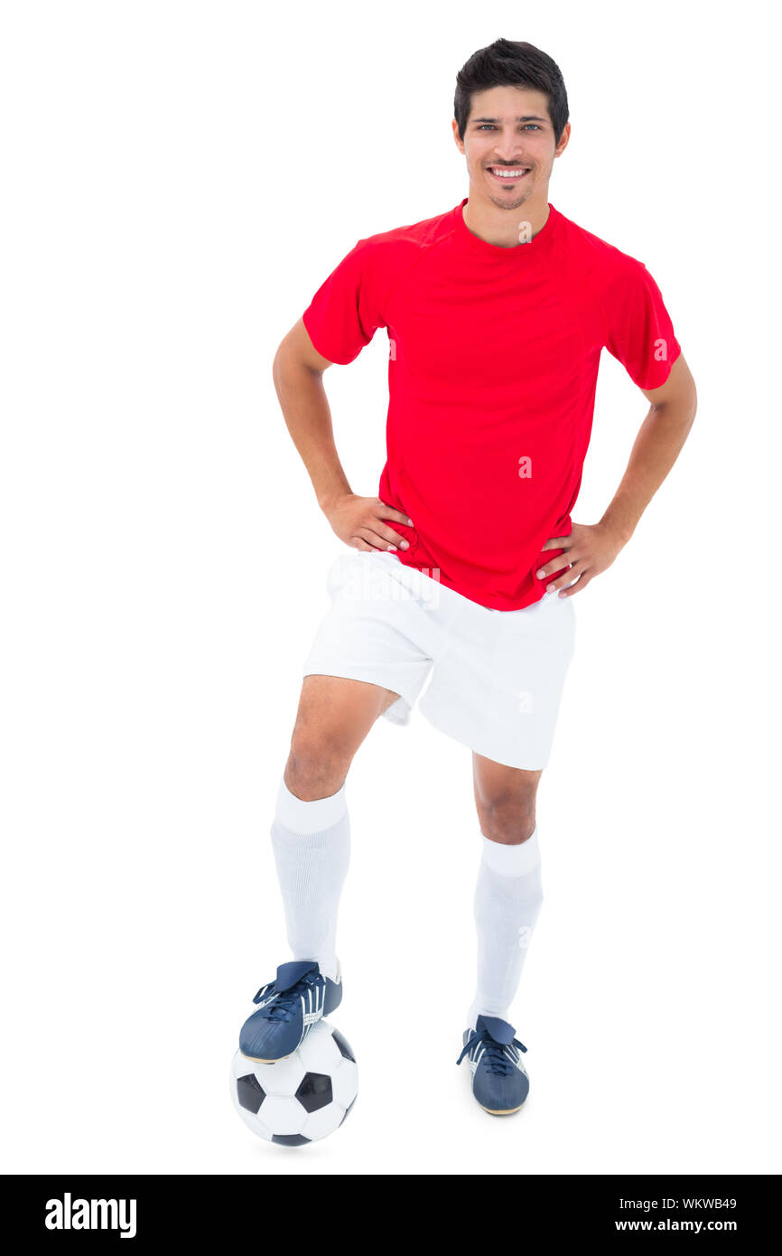 Football player in red standing with ball on white background Stock ...