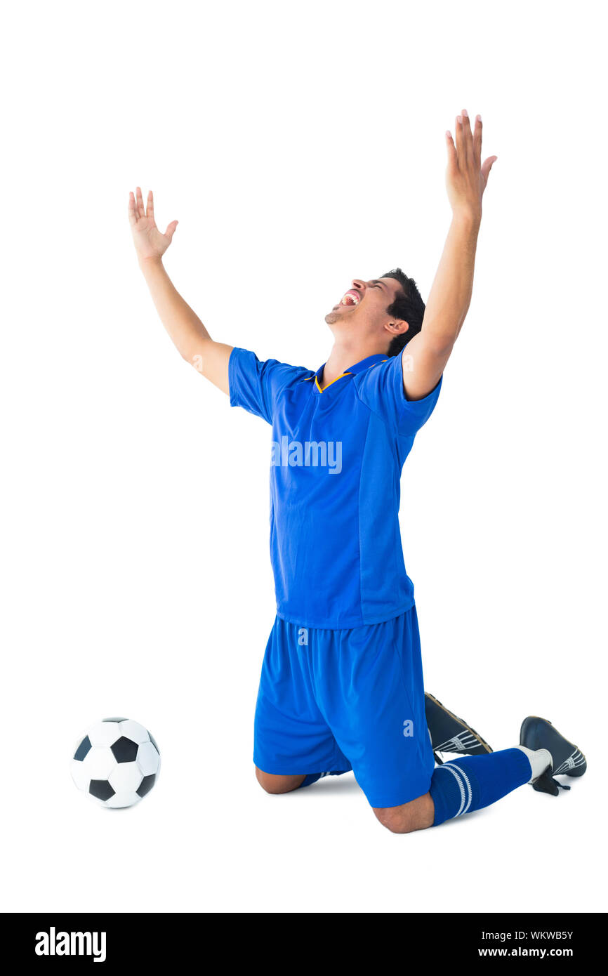 Happy football player in blue celebrating on white background Stock ...