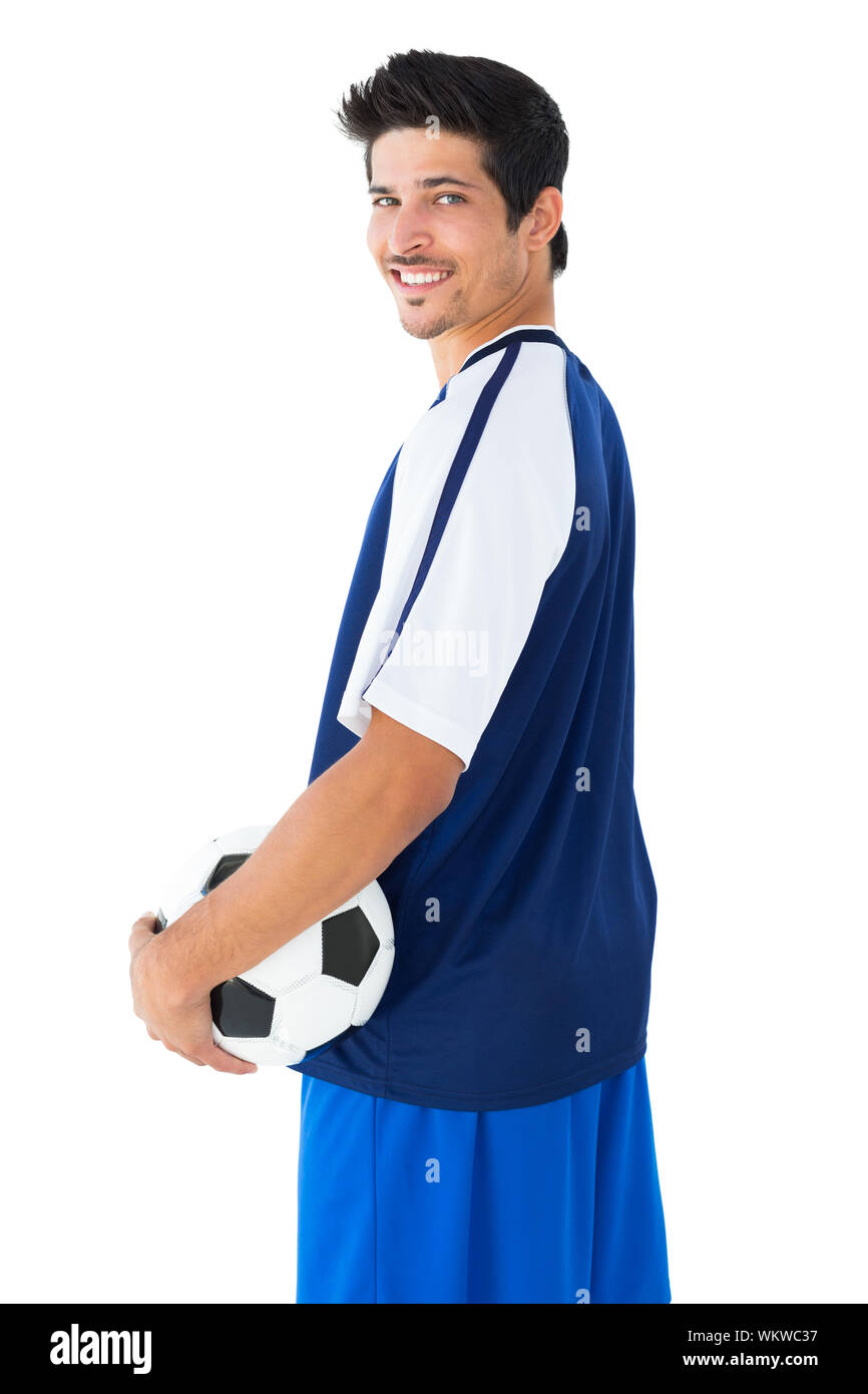 Happy football player in blue holding the ball on white background ...