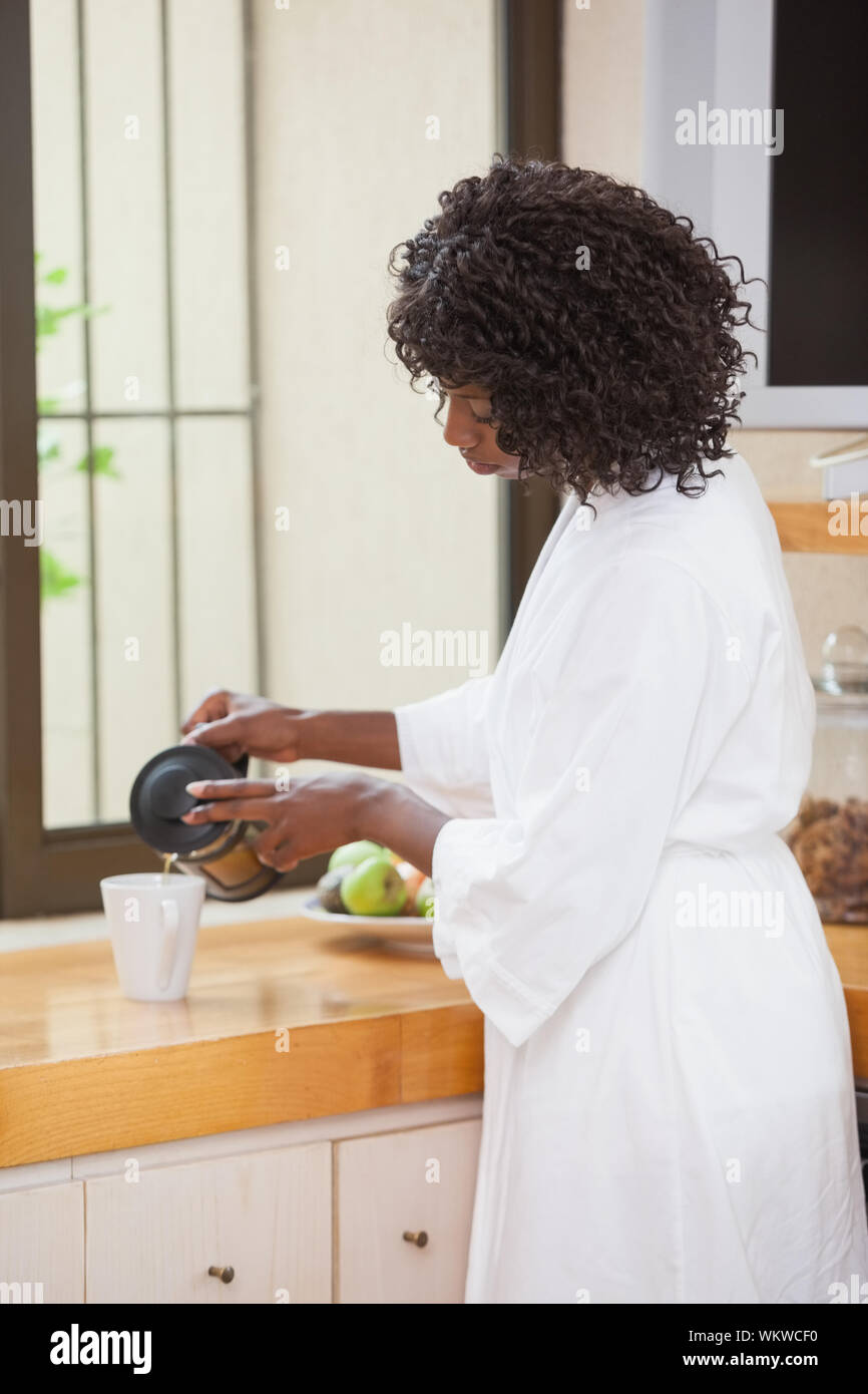 Pretty woman in bathrobe pouring coffee at home in the kitchen Stock ...