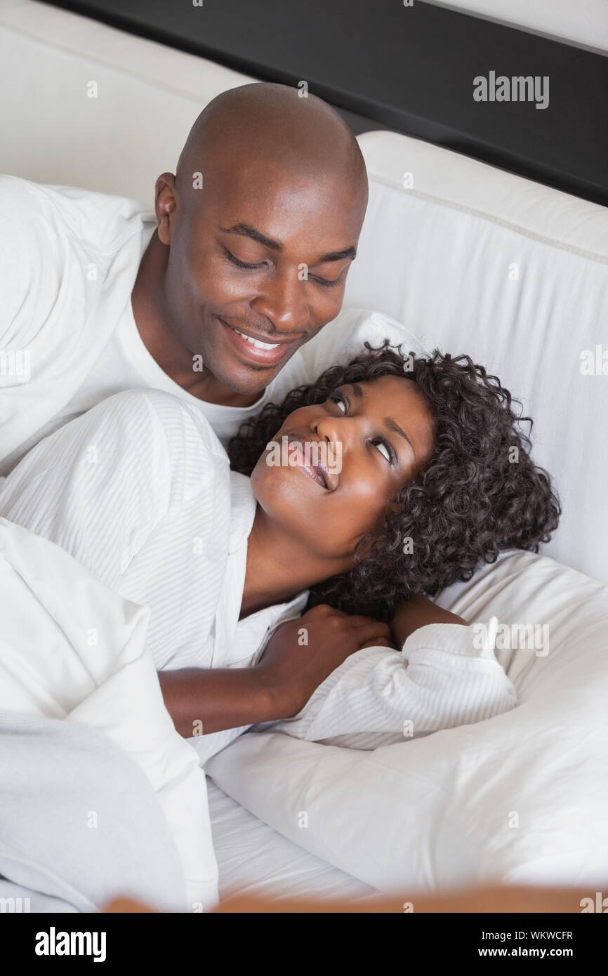 Happy couple cuddling together in bed at home in the bedroom Stock ...
