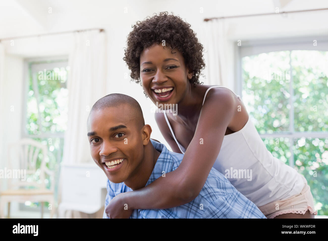 Happy couple cuddling on their bed at home in the bedroom Stock Photo ...