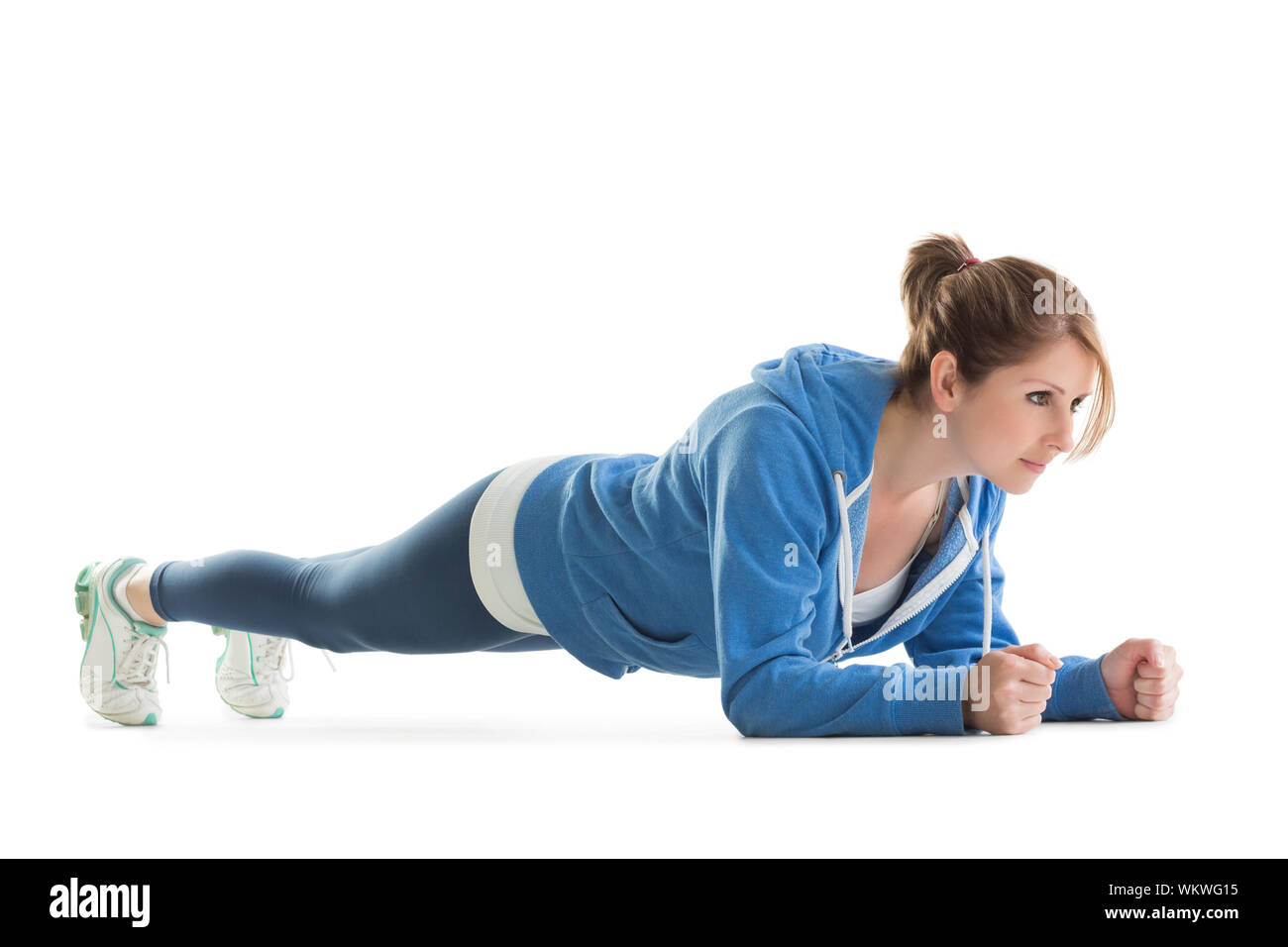 Young woman in basic plank posture over white background Stock Photo ...