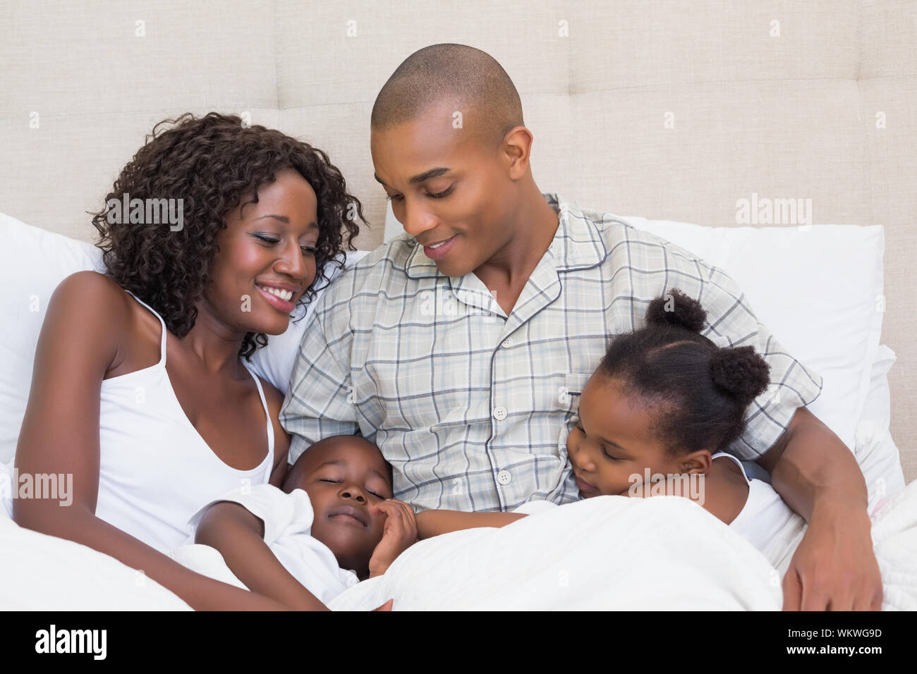 Happy family cuddling in bed together at home in the bedroom Stock ...