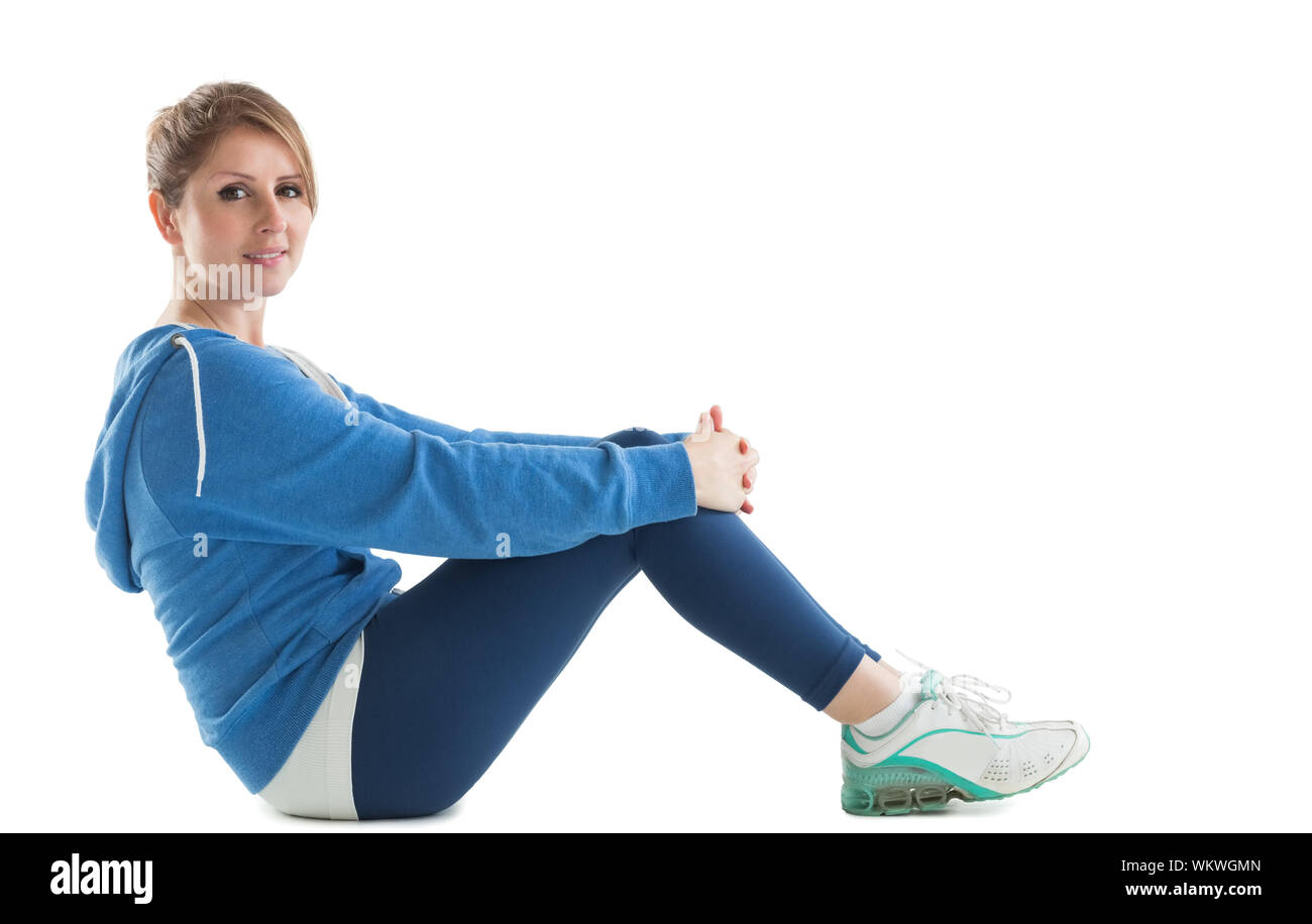 Portrait of a fit young woman sitting over white background Stock Photo ...