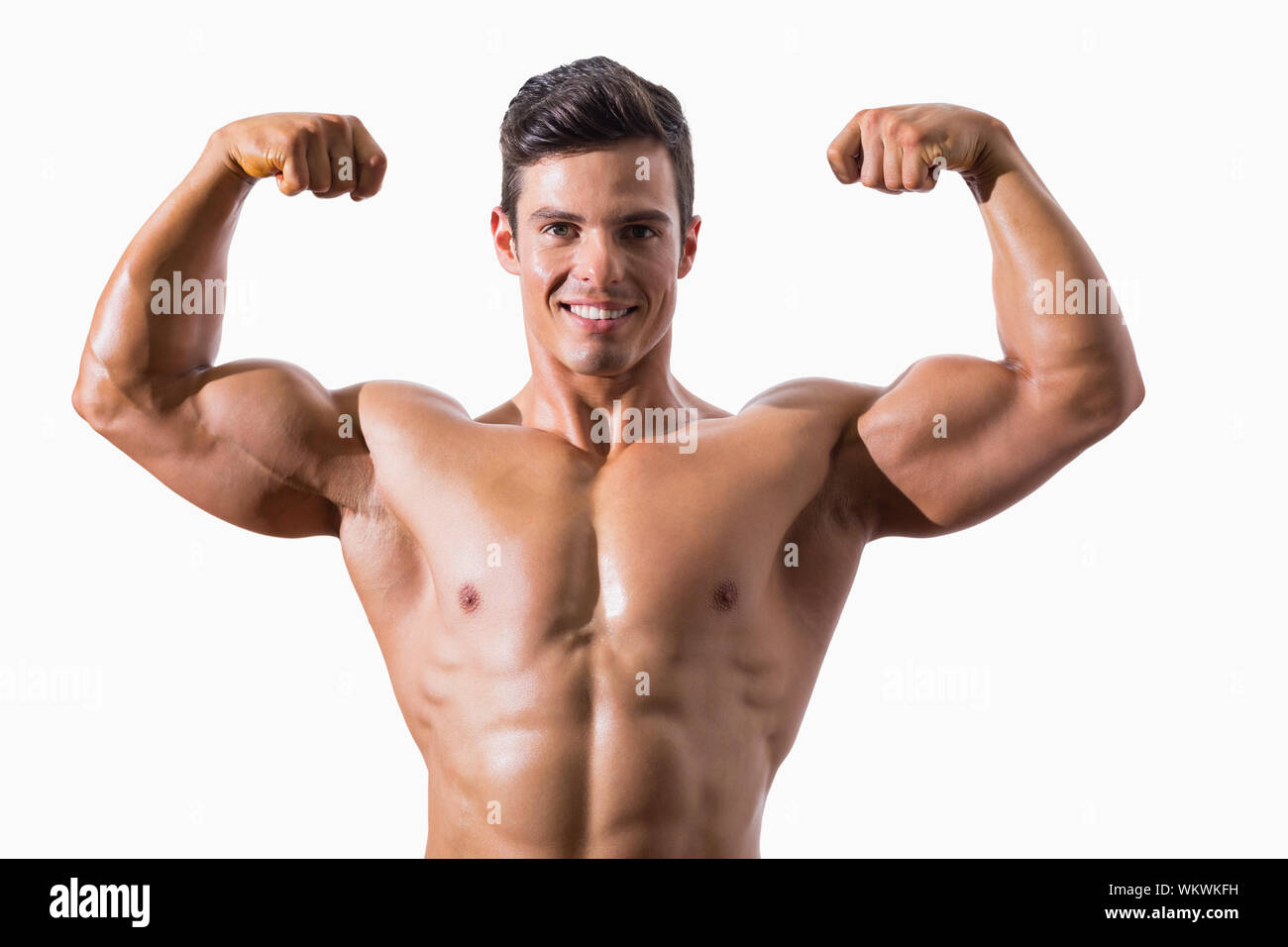 Portrait of a muscular young man flexing muscles over white background ...