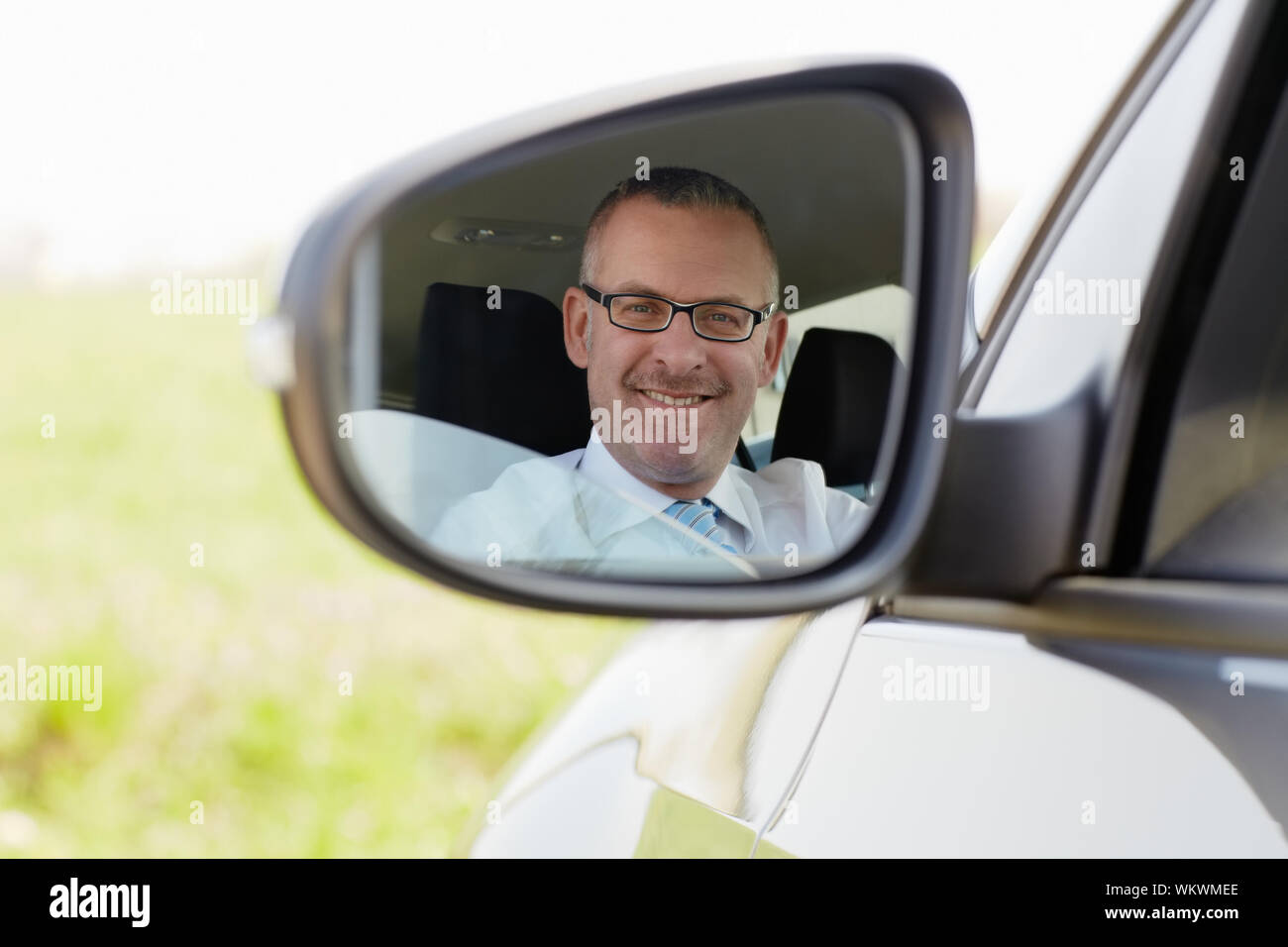 mature caucasian business man looking at camera through rear view ...