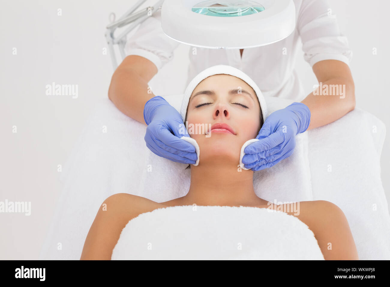 Hands cleaning woman's face with cotton swabs at spa center Stock Photo ...