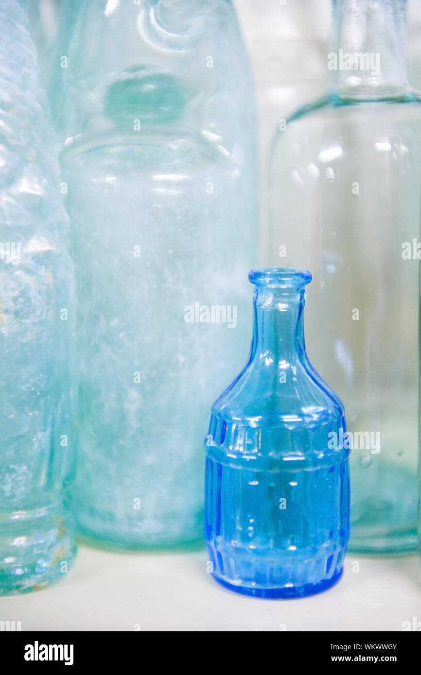 Little blue bottle in front of other antique glass Stock Photo - Alamy