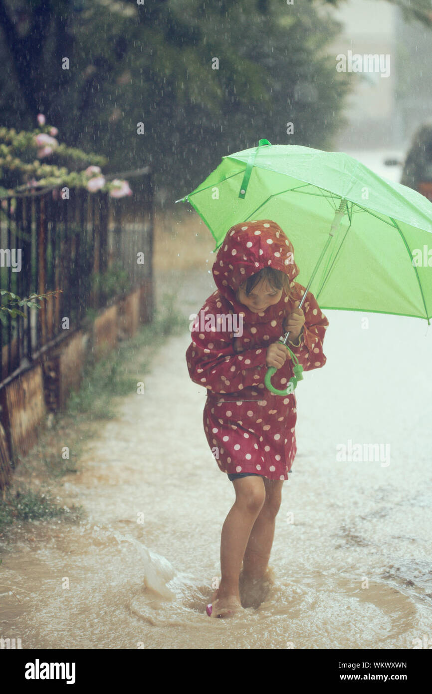 Little child walking in the rain Stock Photo - Alamy