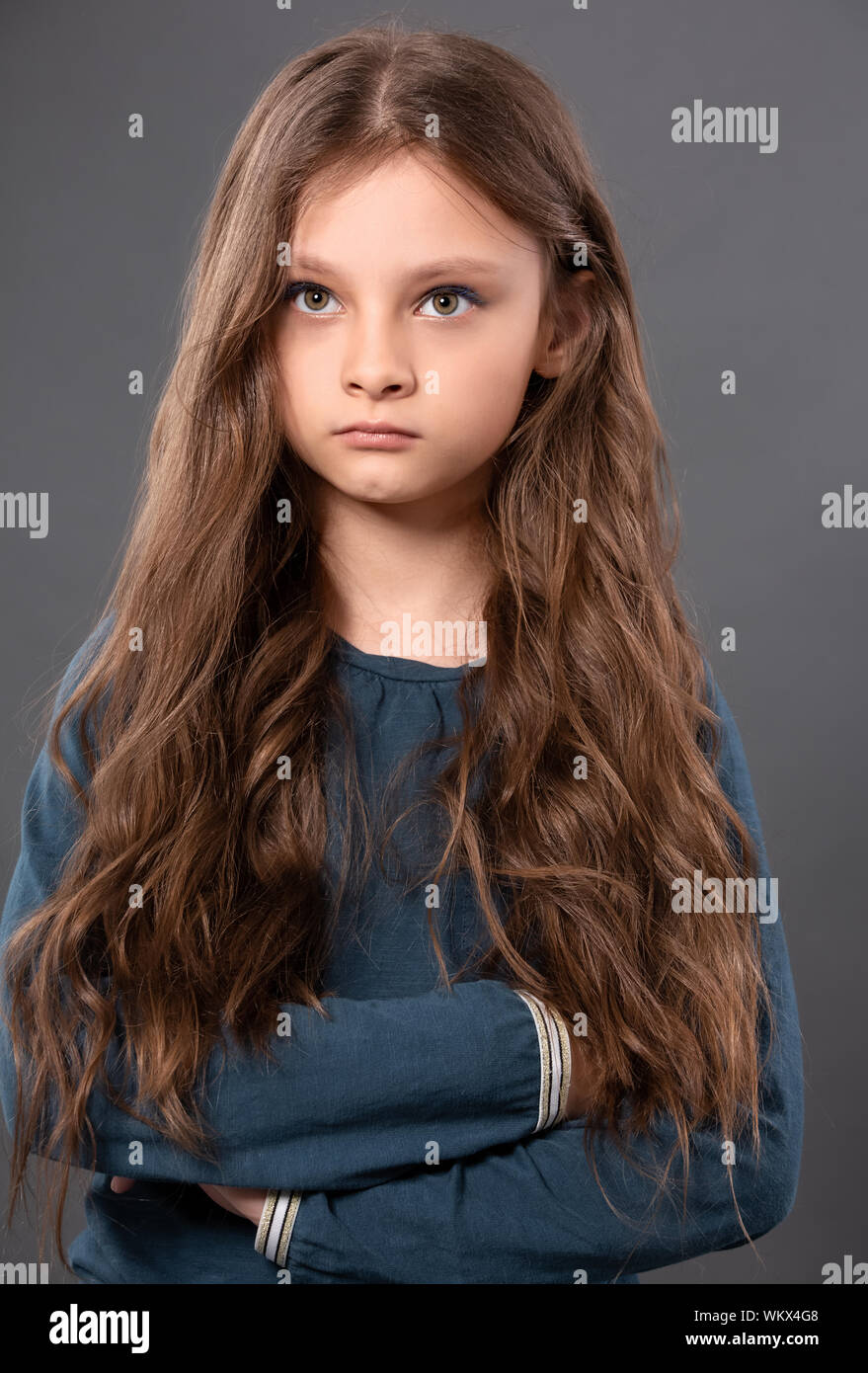 Thinking pupil kid girl with folded arms thinking and serious looking ...