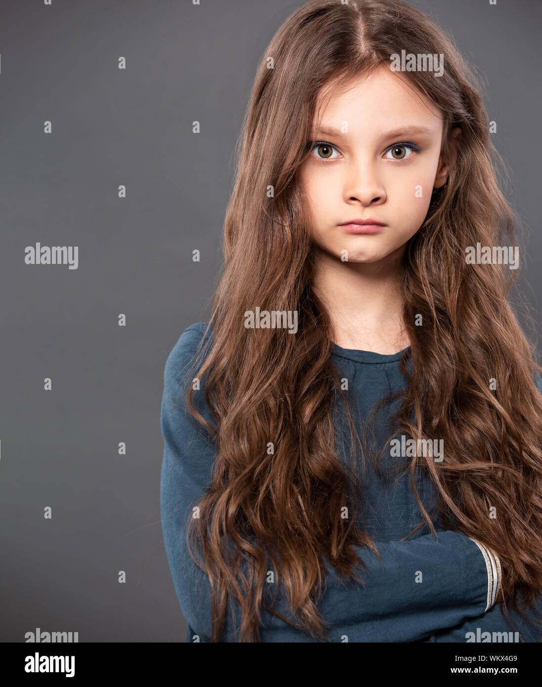 Thinking angry pupil kid girl with folded arms thinking and have an ...