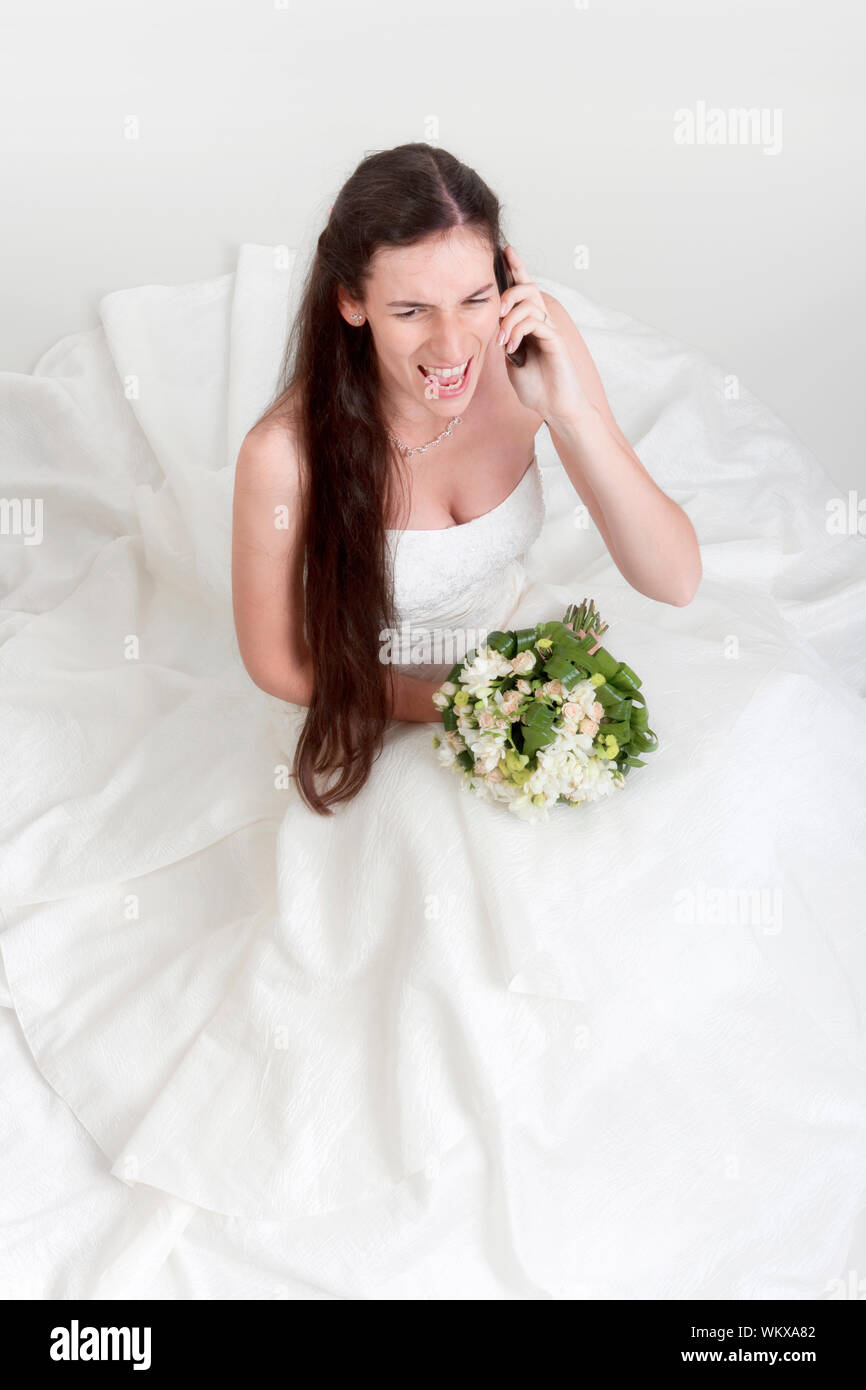 angry bride in wedding dress and bouquet yelling in mobile phone Stock ...