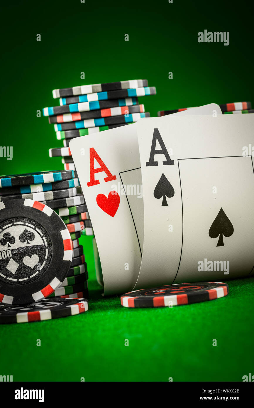 Stack of chips and two aces on the table on the green baize - poker ...