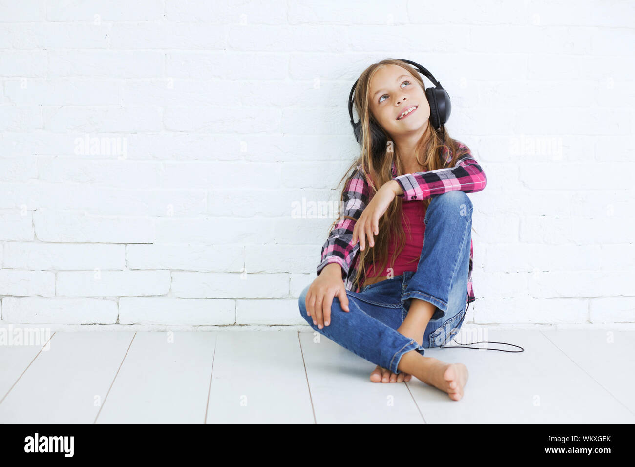 8-9 years old stylish teen girl with black headphones posing on white ...
