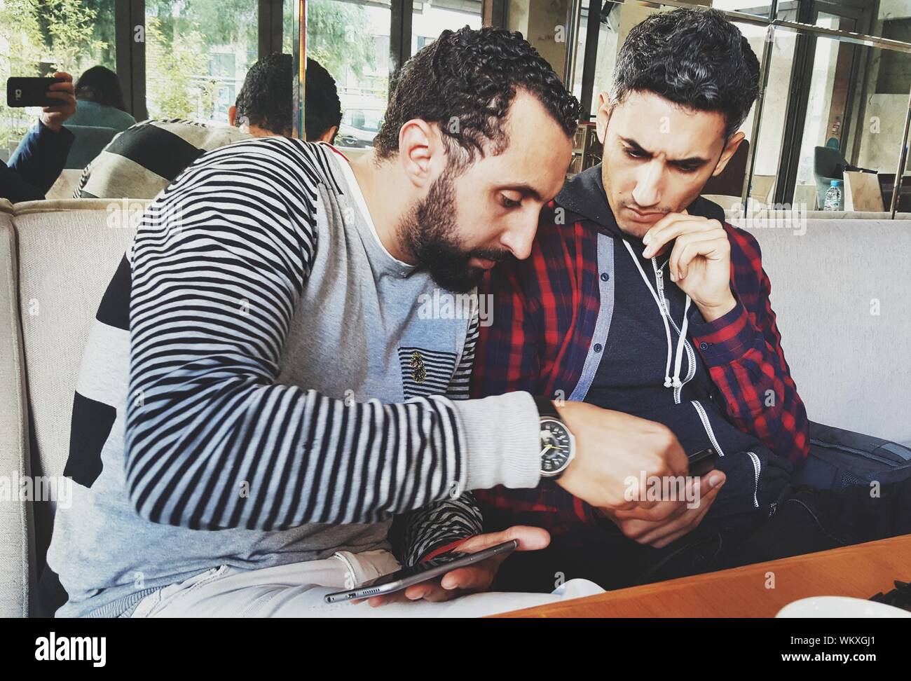 Two Young Men Using Smart Phones Stock Photo - Alamy
