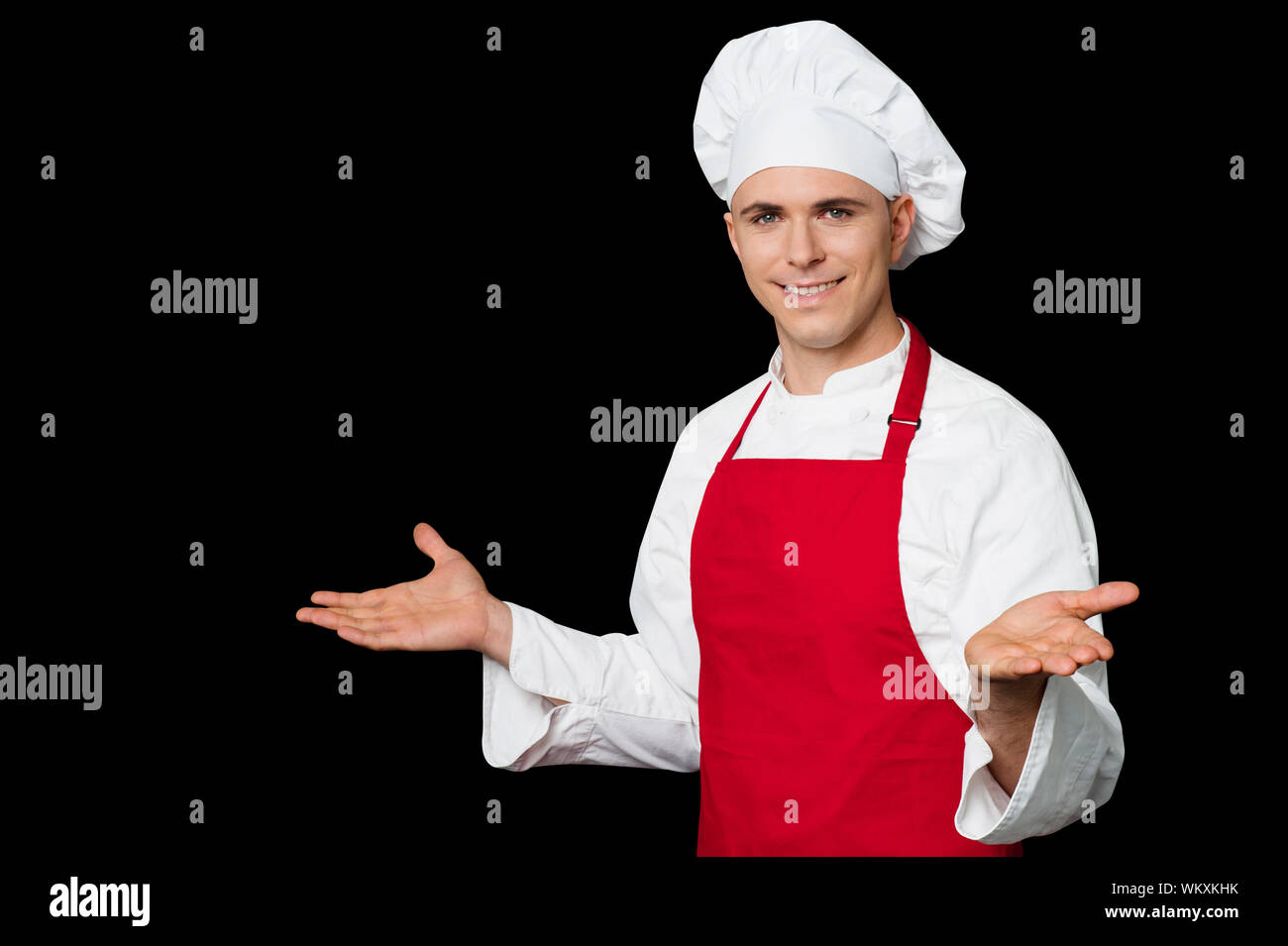 Chef posing with arms wide open, black background Stock Photo - Alamy