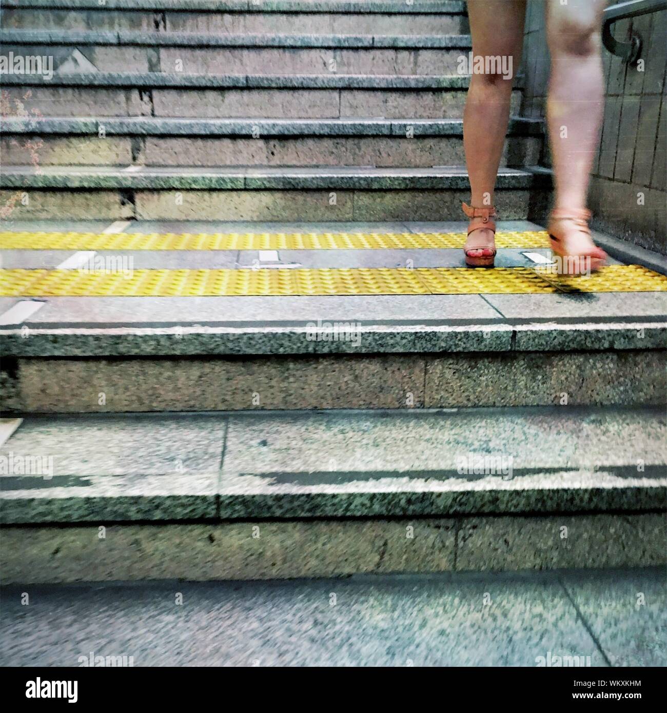 Woman climbing down the stairs hi-res stock photography and images - Alamy