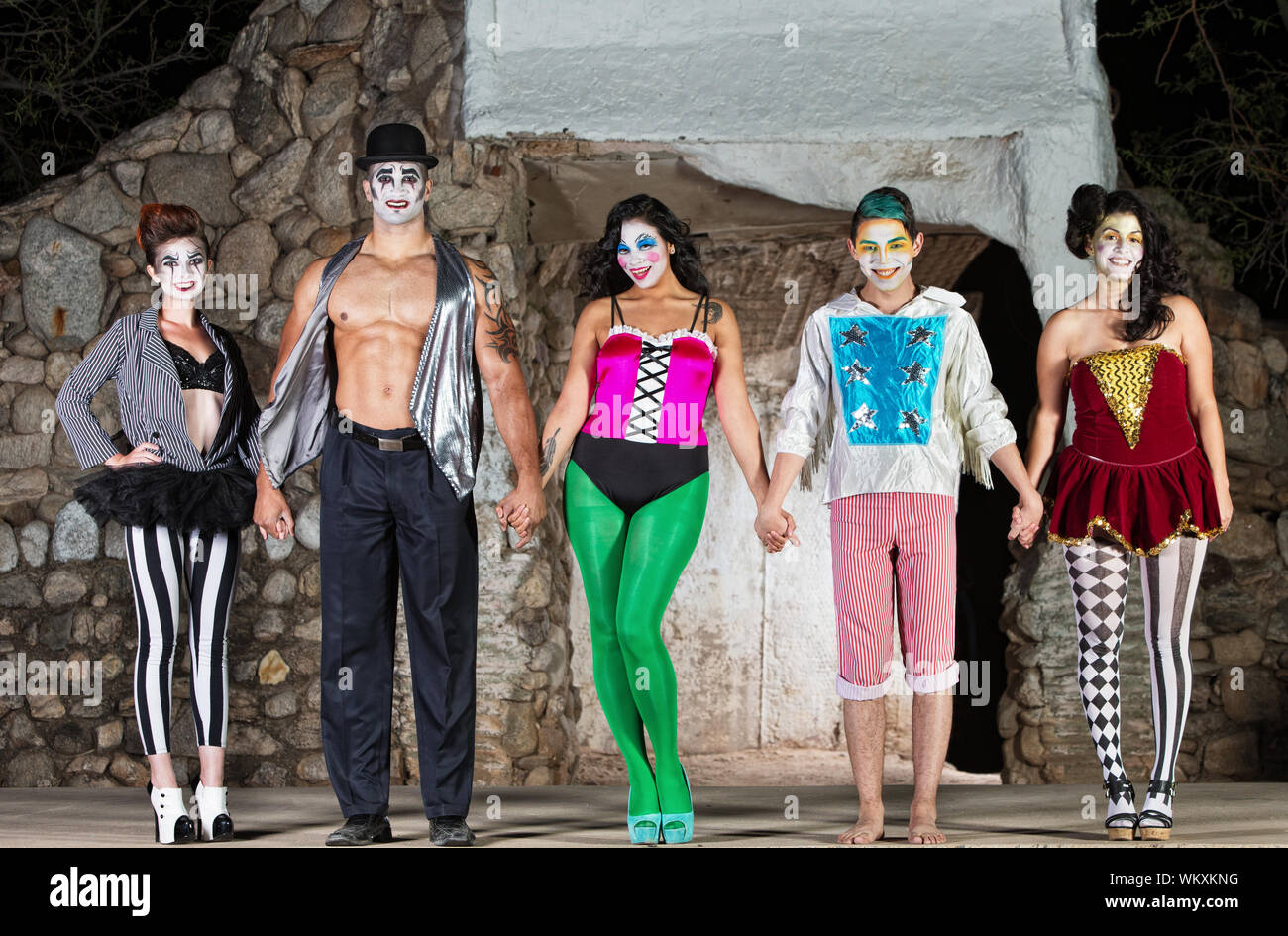 Group of mixed cirque clowns bowing on stage Stock Photo - Alamy