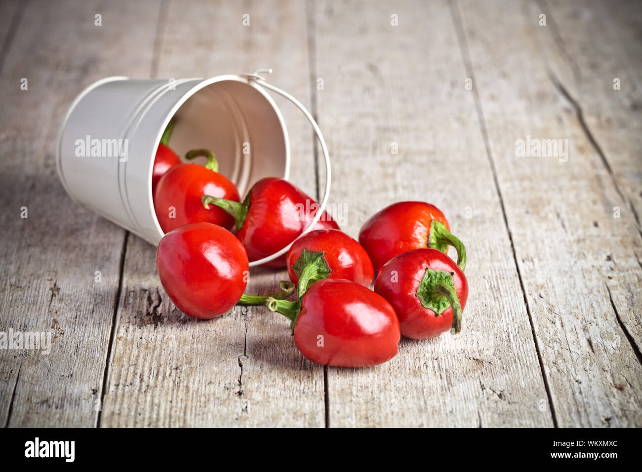 red hot chilli peppers in little bucket on rustic wooden table Stock ...
