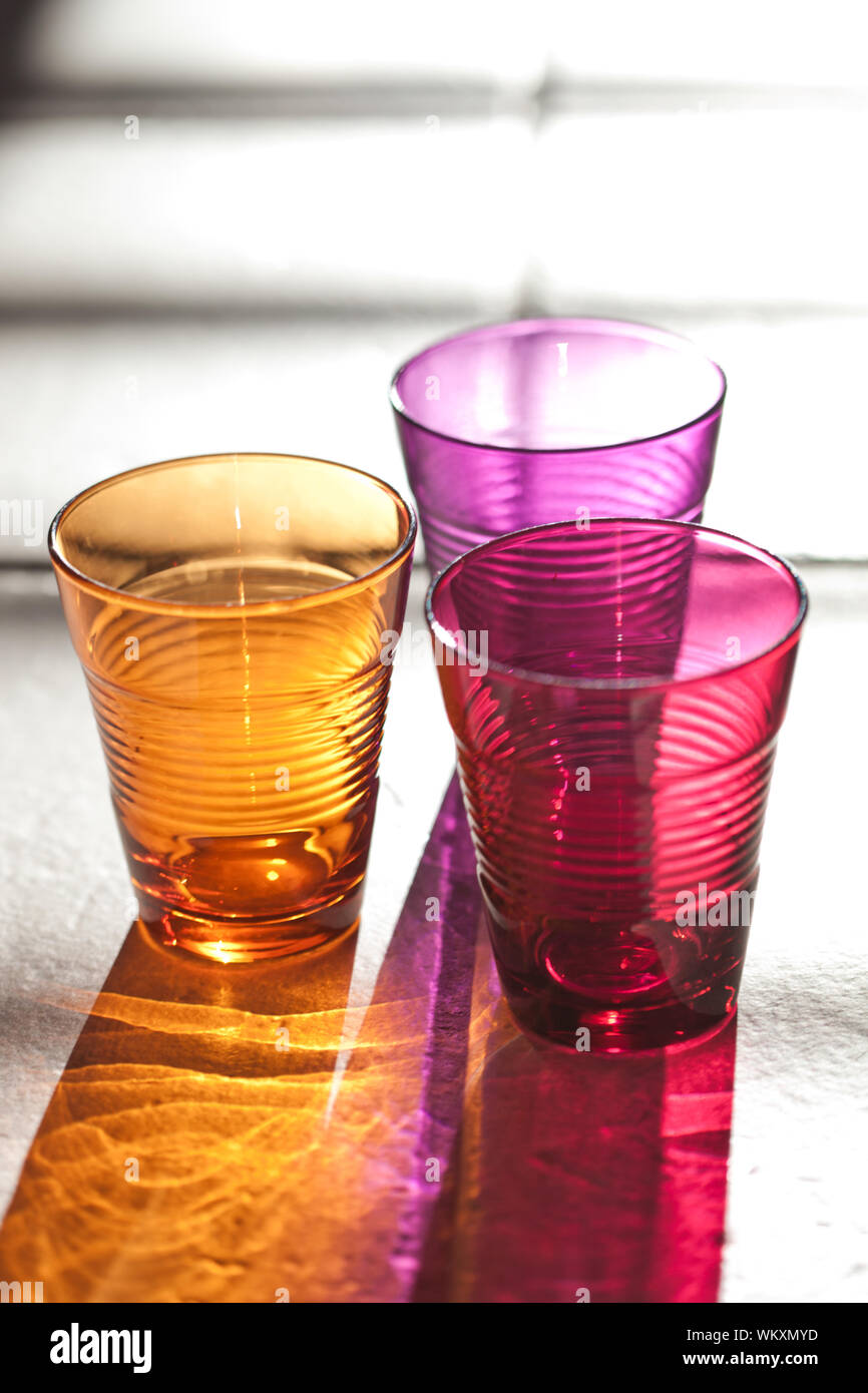 three color drink glasses with reflection on stone background Stock ...
