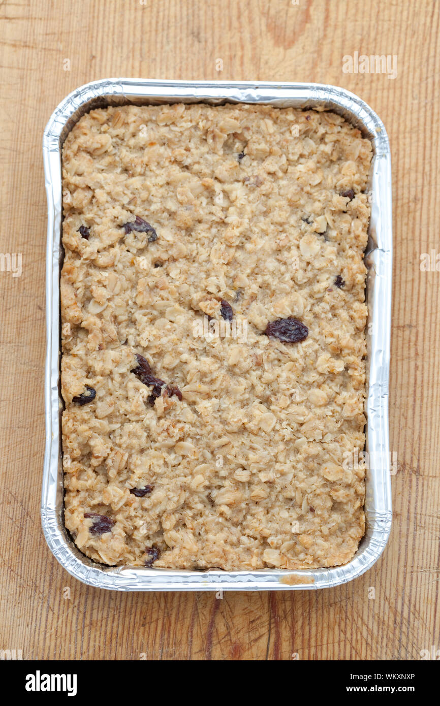 Flapjack in a silver baking tray on a wooden board Stock Photo - Alamy