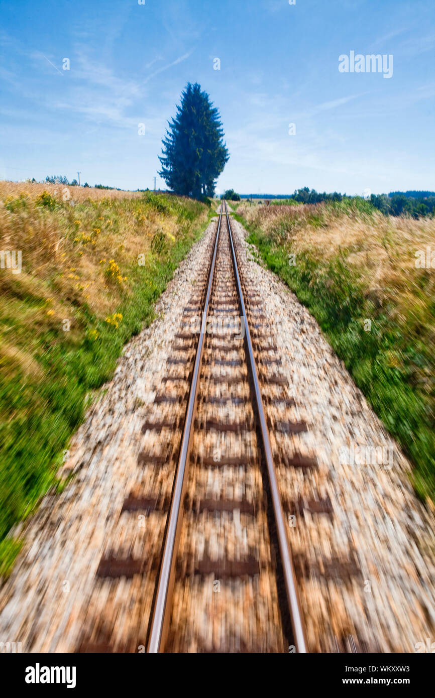 View of narrow gauge railroad track from rear window of train riding ...