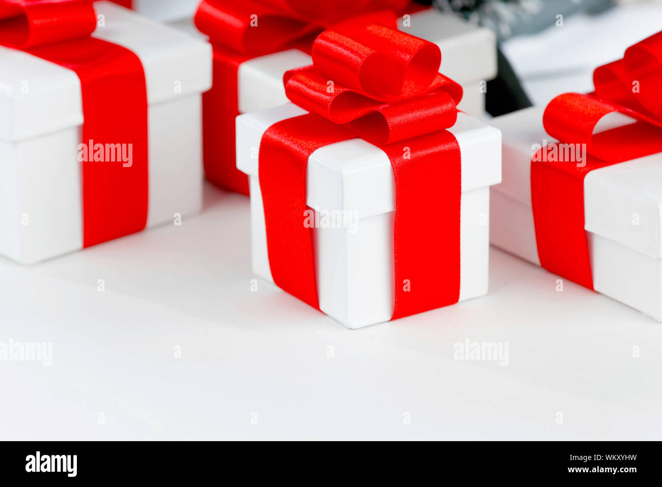 White boxes with gifts decorated with red ribbons on white background ...