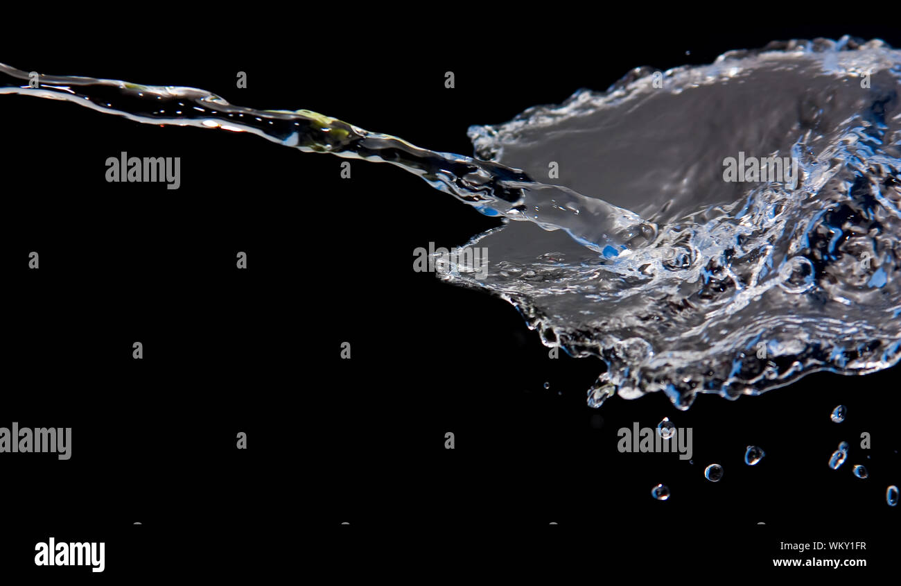 Splash water on the background of black wall Stock Photo - Alamy