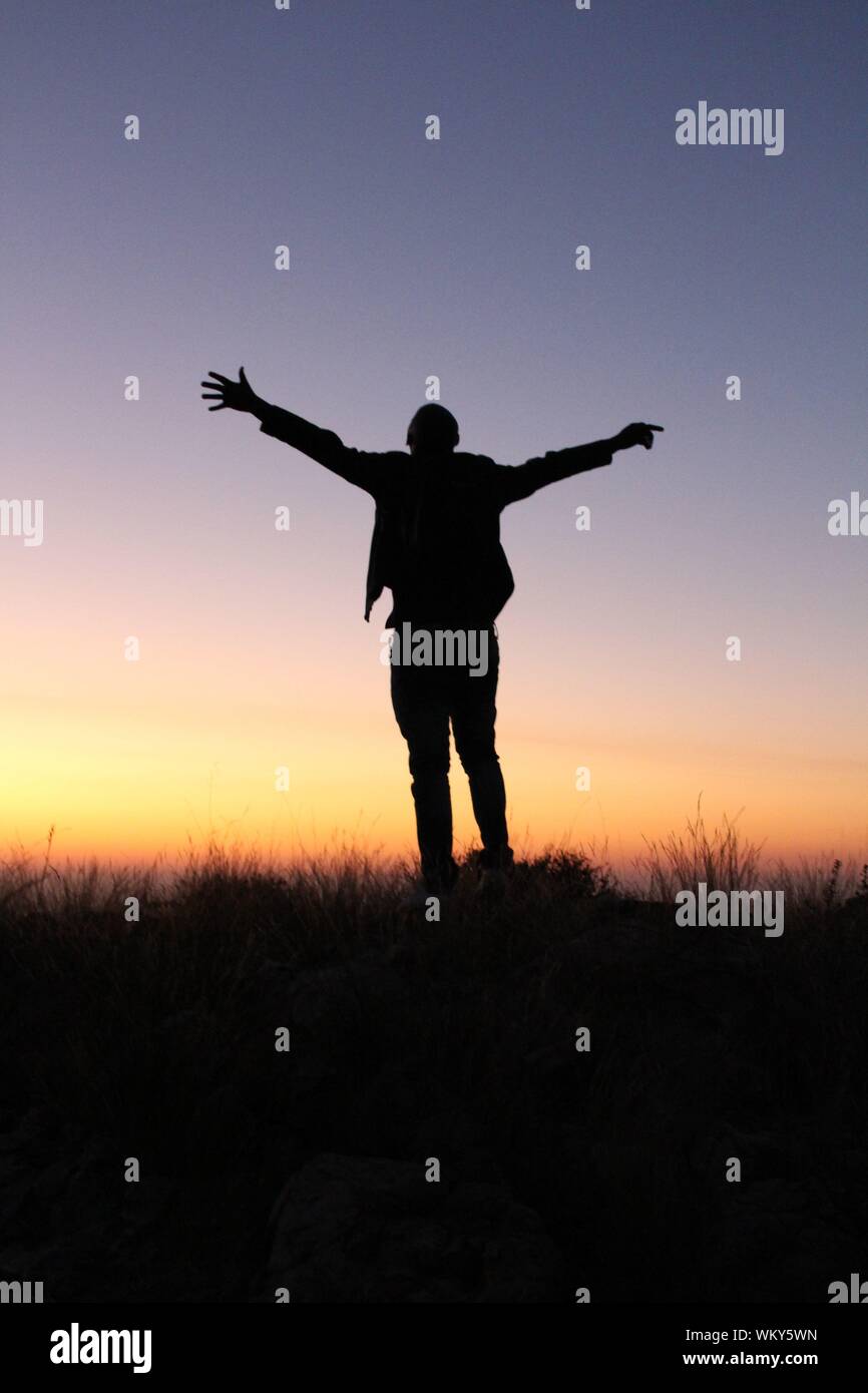 Silhouette man standing arms outstretched hi-res stock photography and ...