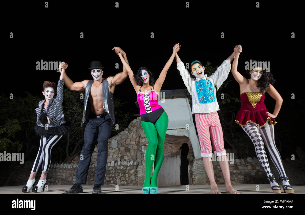 Group of happy clowns holding hands and celebrating Stock Photo - Alamy