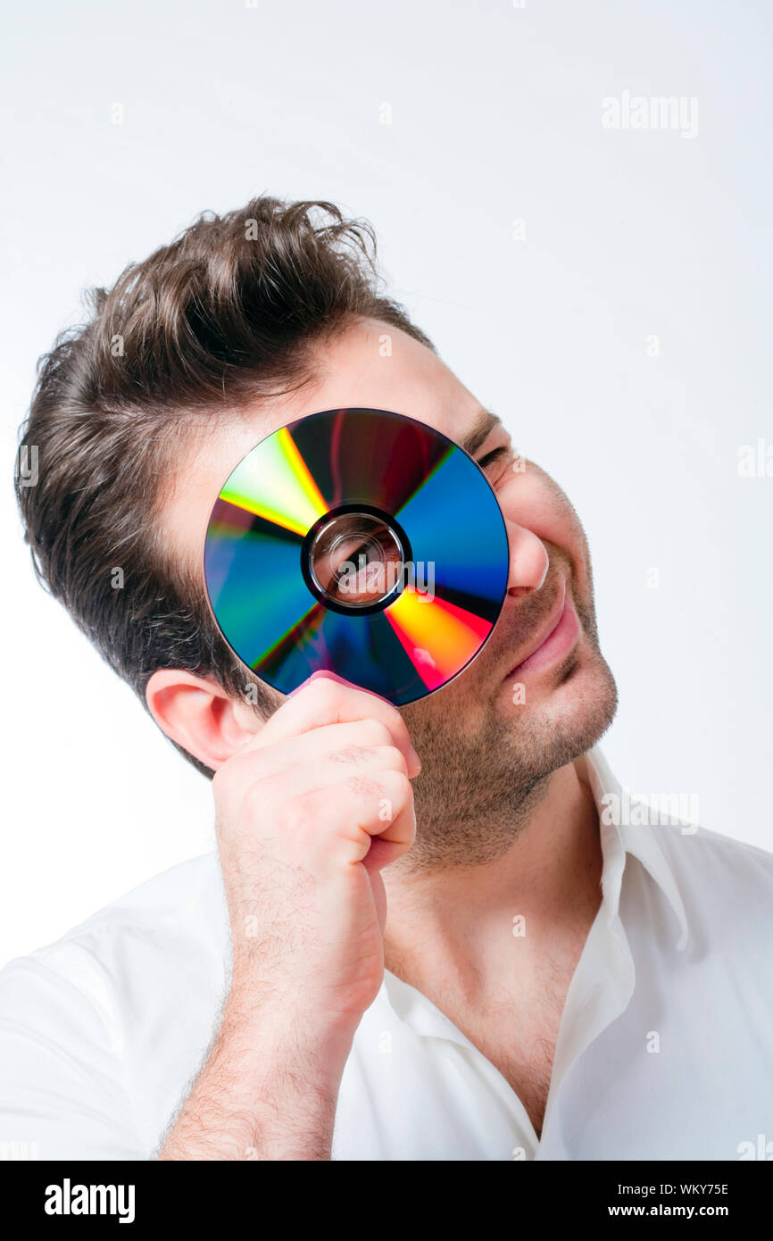 man in shirt standing smiling looking through CD - isolated on white ...