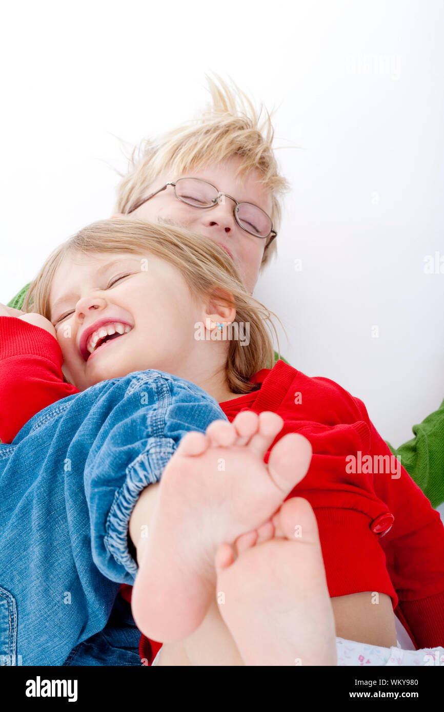 two young siblings fooling around with each other - isolated on white ...