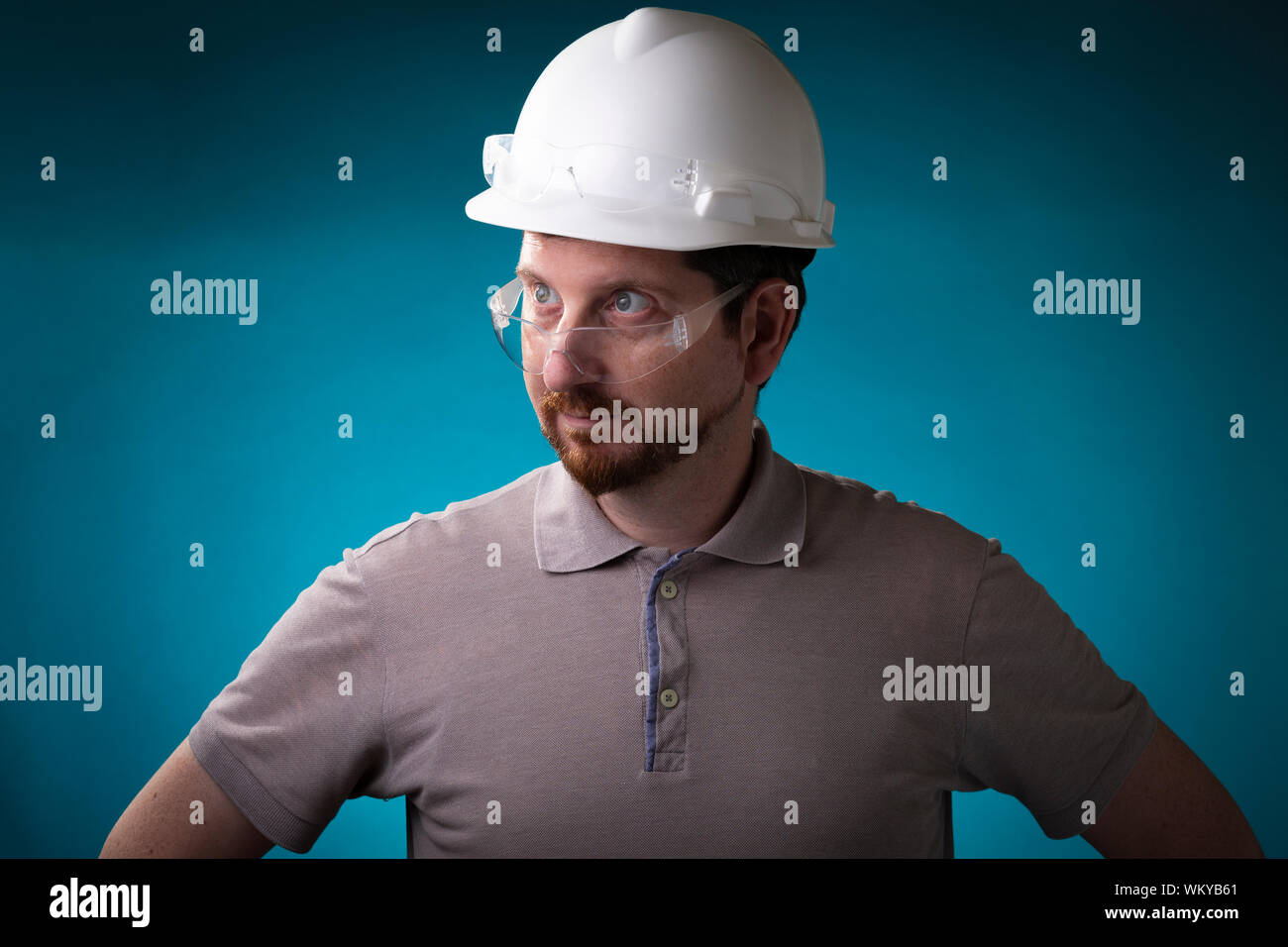 Architect with beard, protective glasses and white safety helmet ...