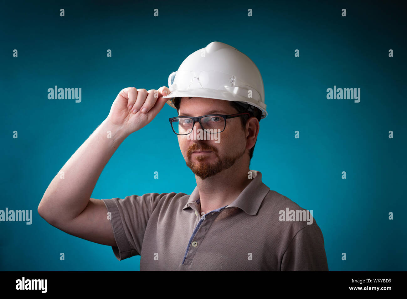 Male with beard and glasses holding a protective construction helmet ...